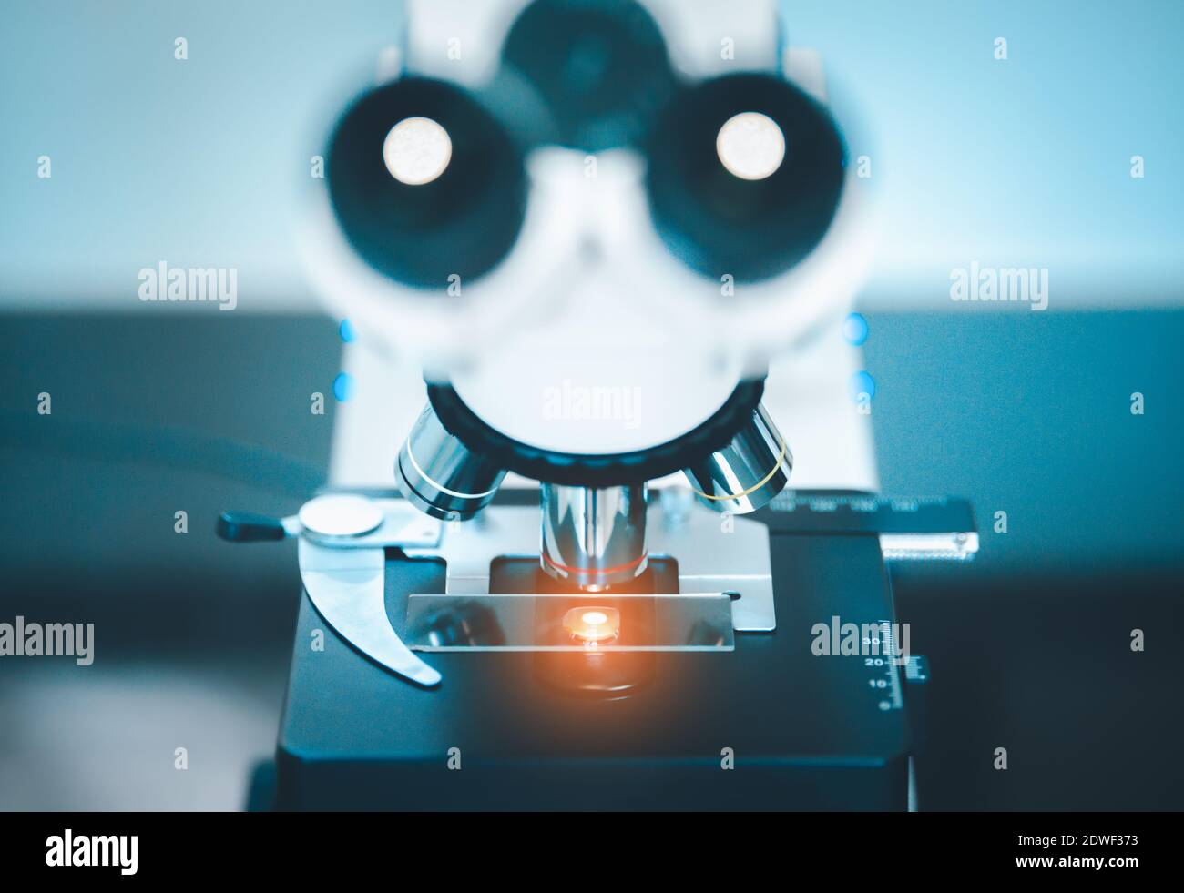 Close up of microscope with test sample in medical research lab or ...