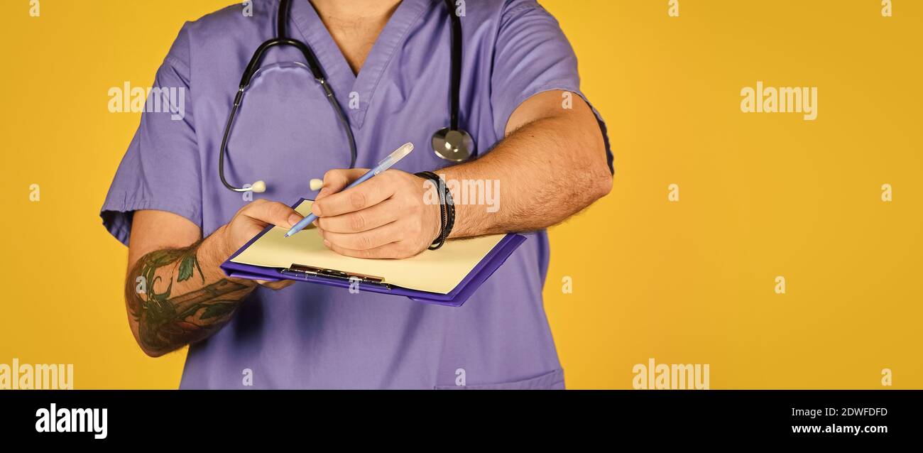 nurse writing some data into the folder of papers. male hospital ...