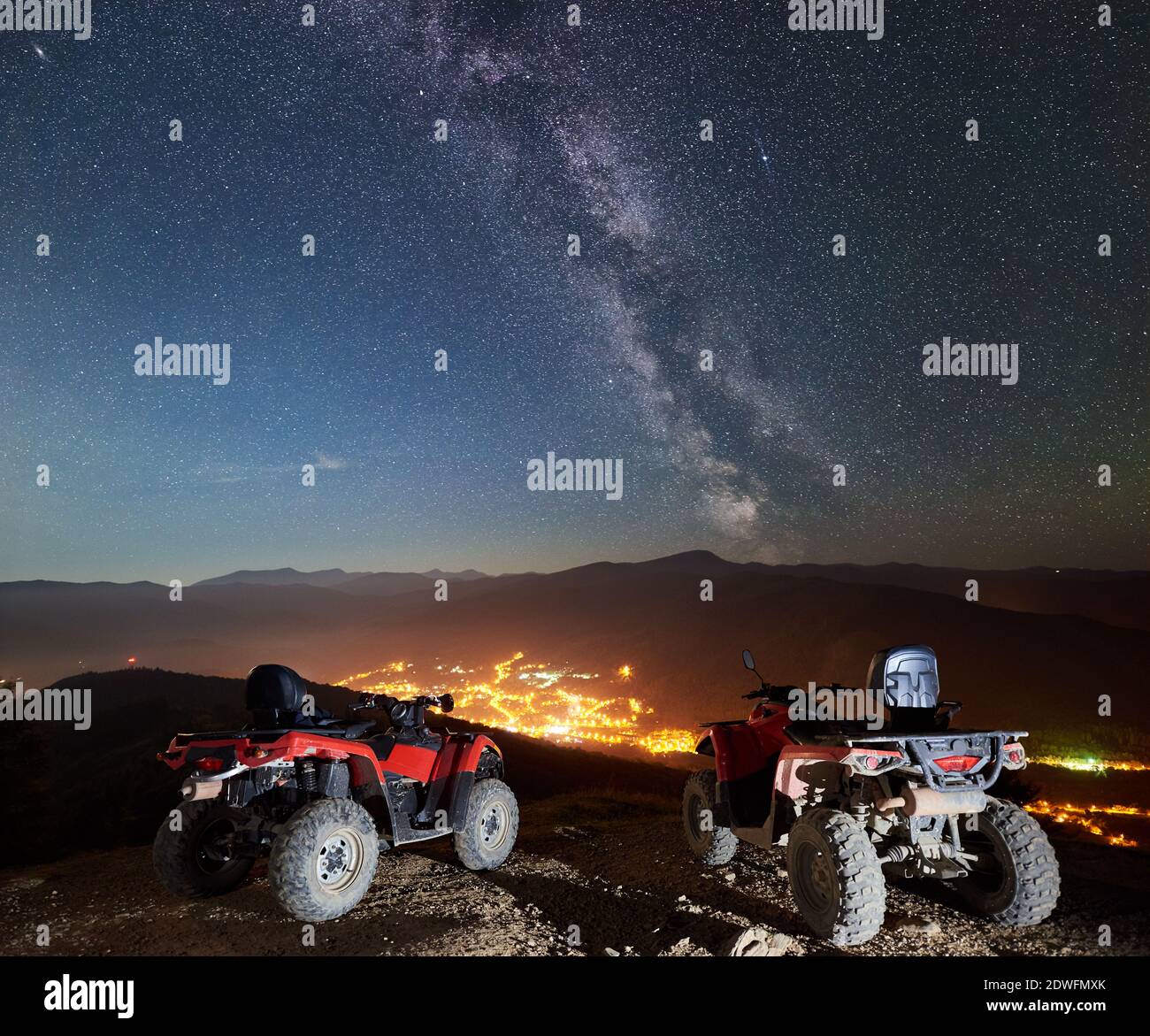 Night picture. Two atv quad motorbikes standing on the top of mountain ...