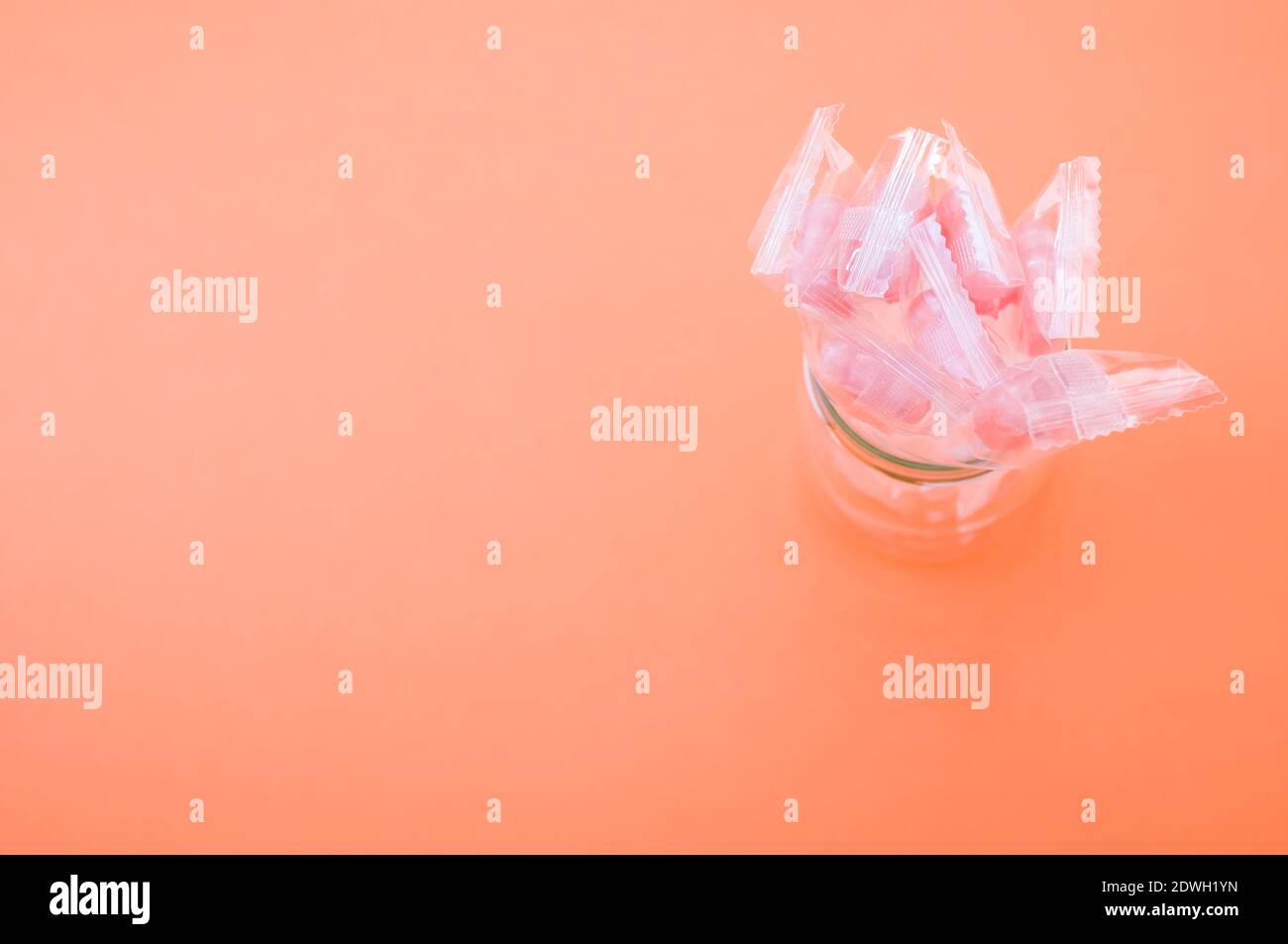 A closeup shot of yummy candies in plastic bags in a jar isolated on a ...