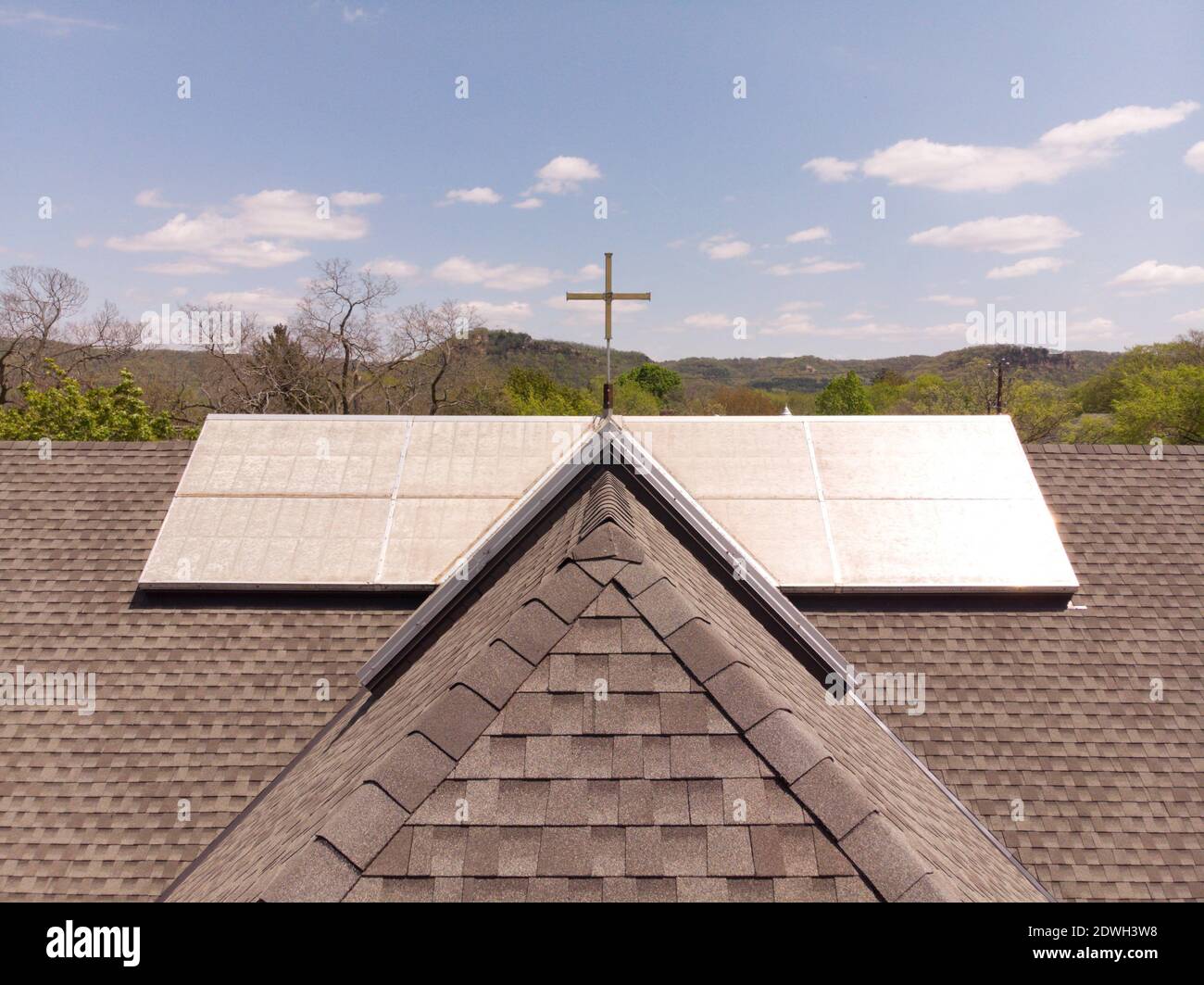 A cross on a shingles roof church Stock Photo - Alamy