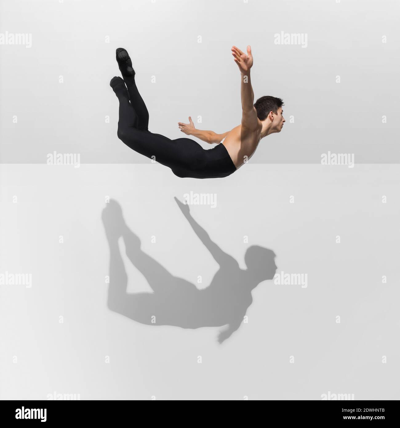 Falling down. Stylish young male athlete on white studio background ...