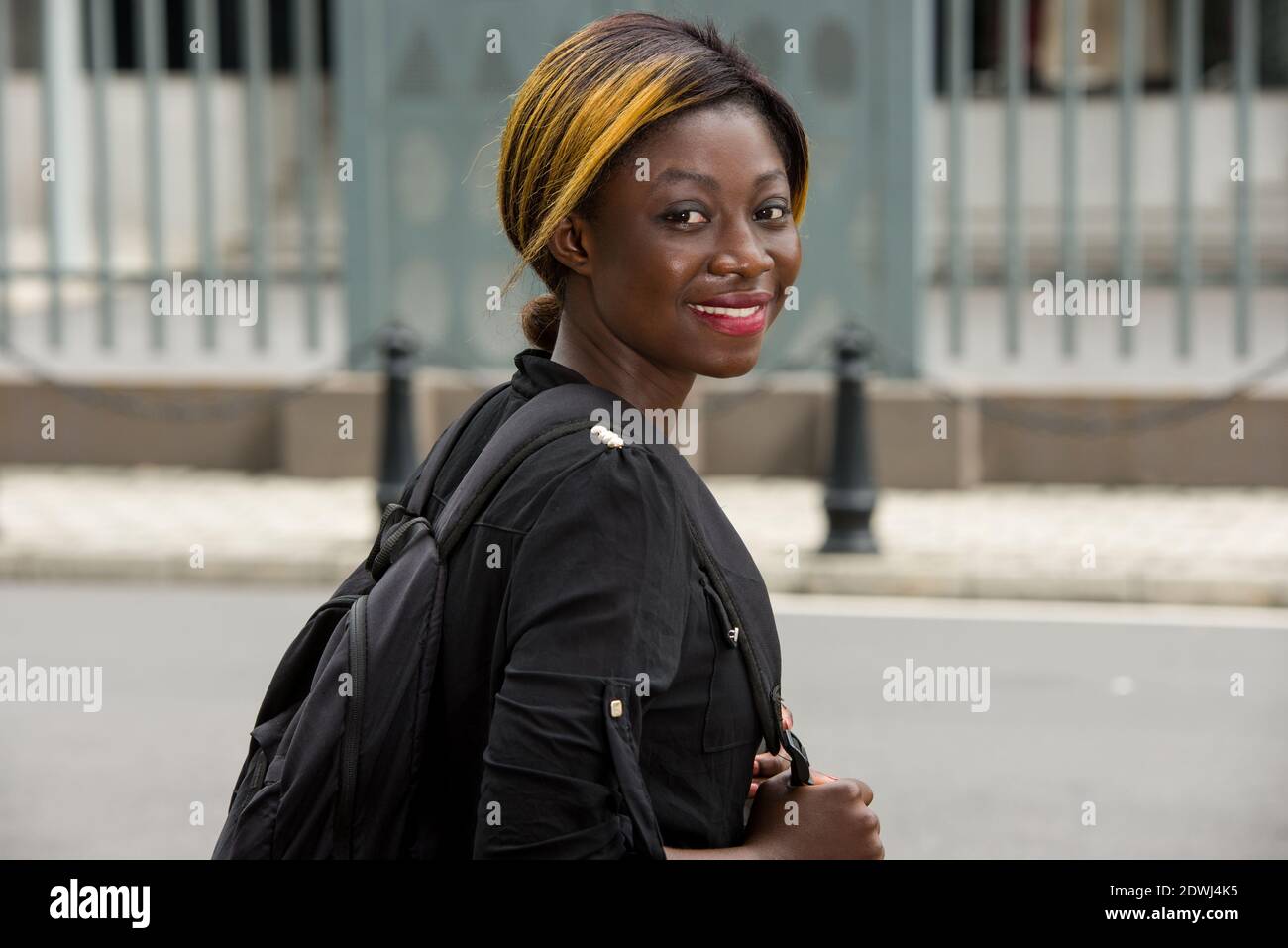 student standing backpack looking at camera smiling Stock Photo - Alamy