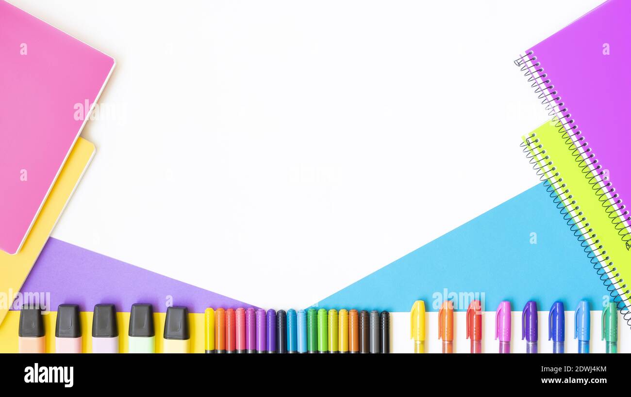 A top view of many colorful stationery products on a white background ...