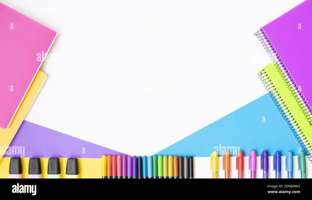 A top view of many colorful stationery products on a white background ...