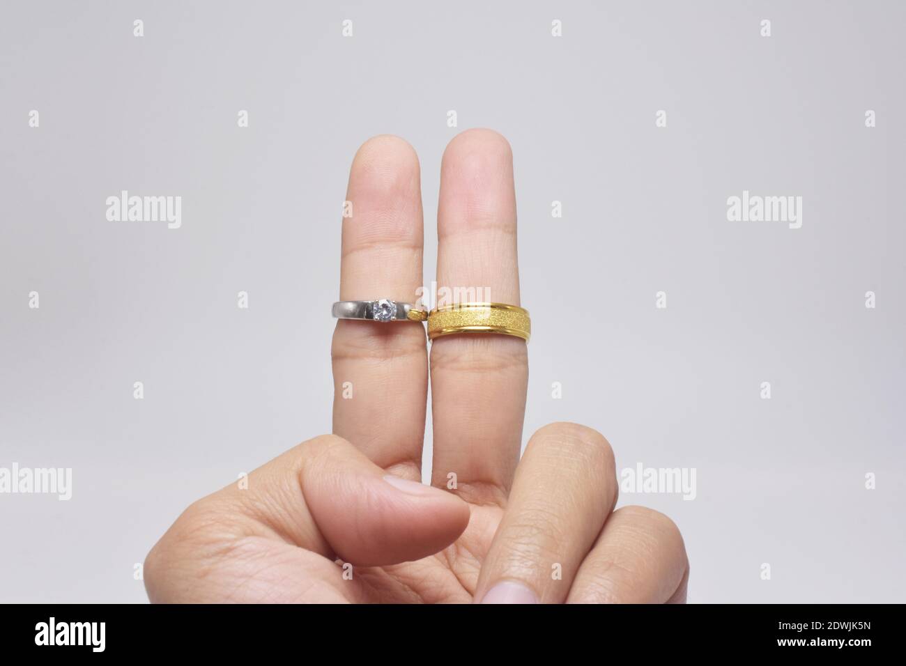 Two Wedding rings are in the fingers on white background Stock Photo ...