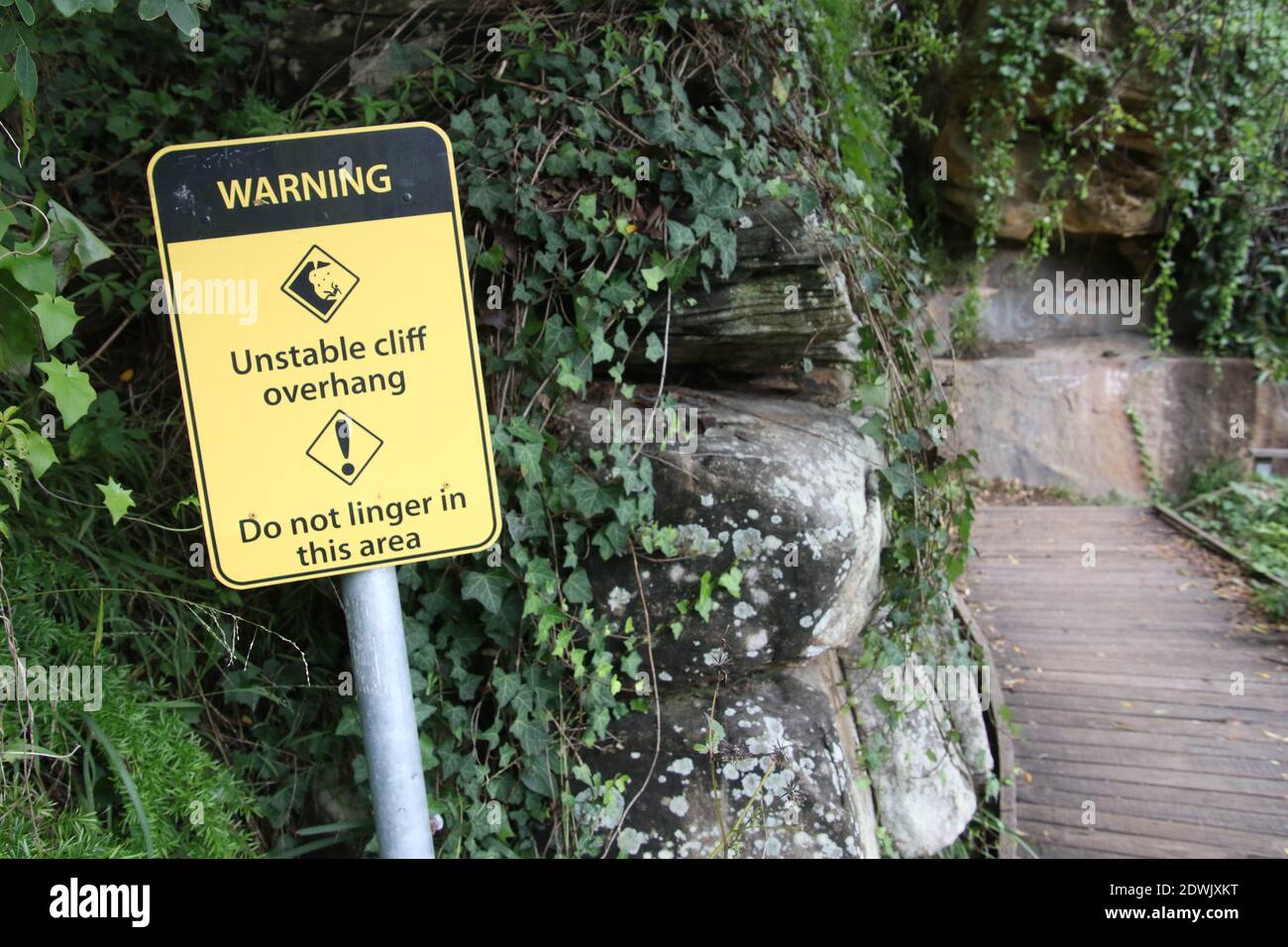‘Warning unstable cliff overhang. Do not linger in this area’ sign next ...