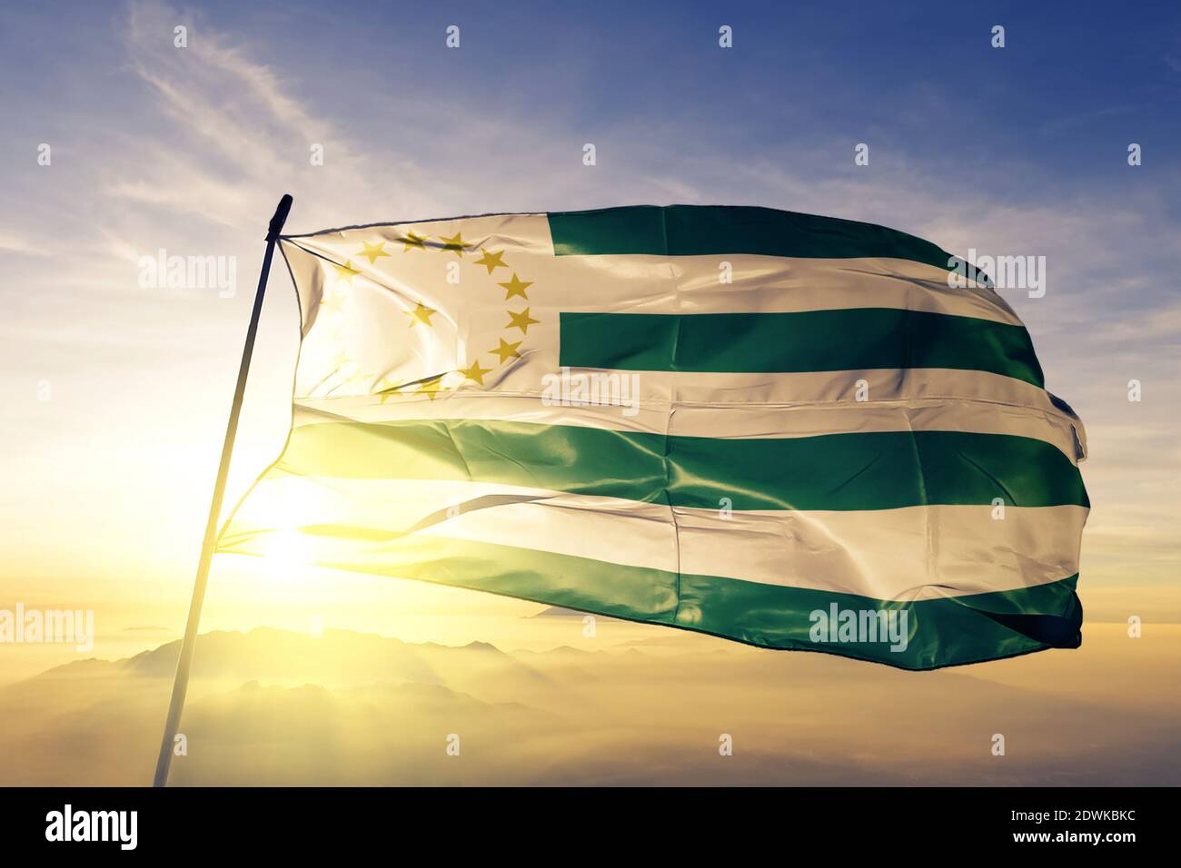 Caqueta department of Colombia flag waving on the top sunrise mist fog ...