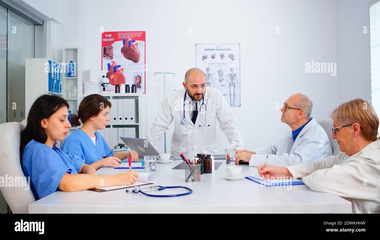 Medical team listening specialist doctor and taking notes during ...