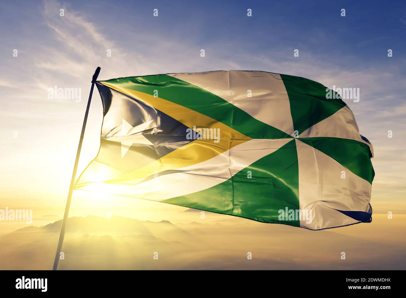 Dili municipality of East Timor flag waving on the top sunrise mist fog ...