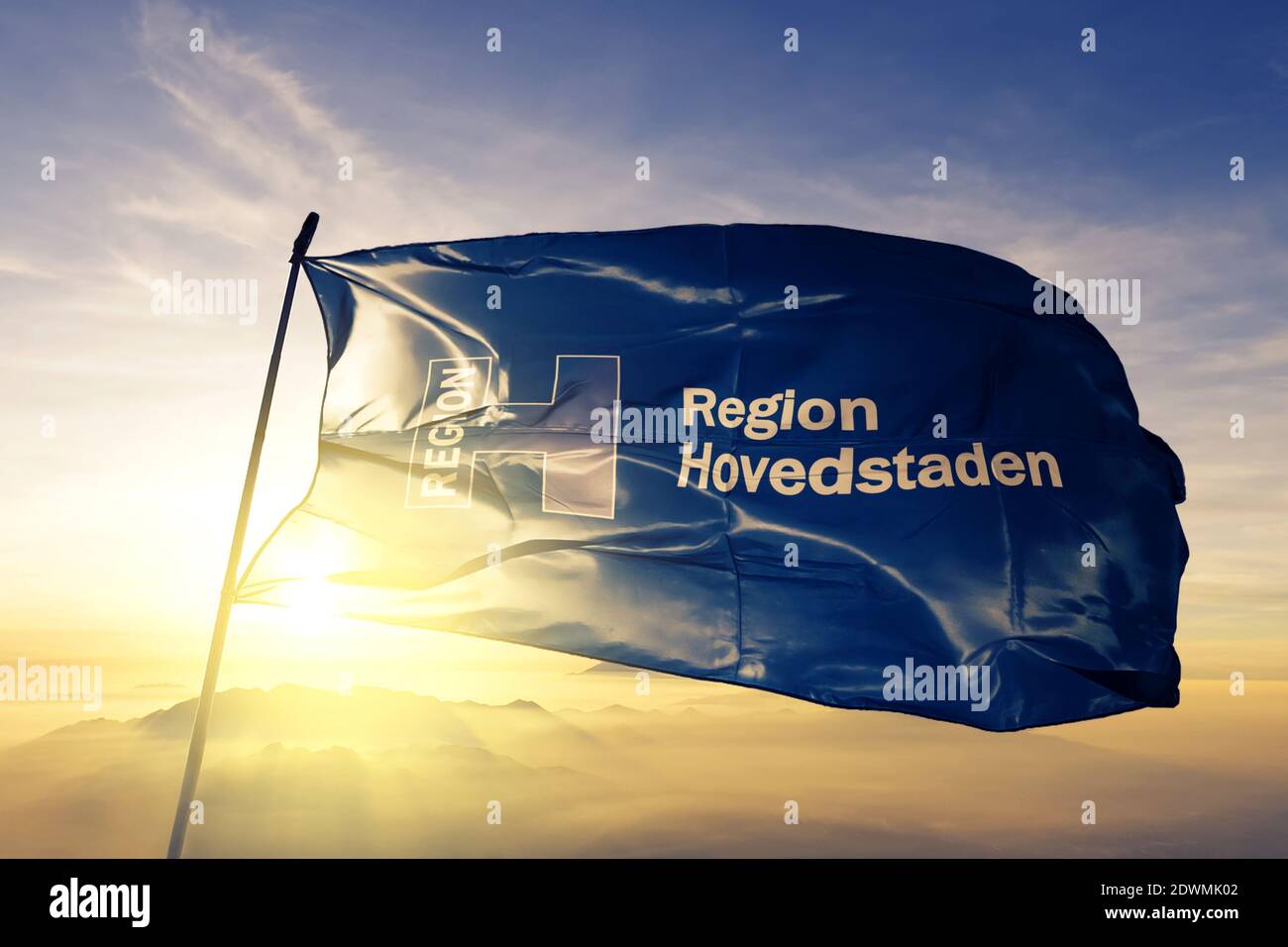 Capital Region of Denmark flag waving on the top sunrise mist fog Stock ...