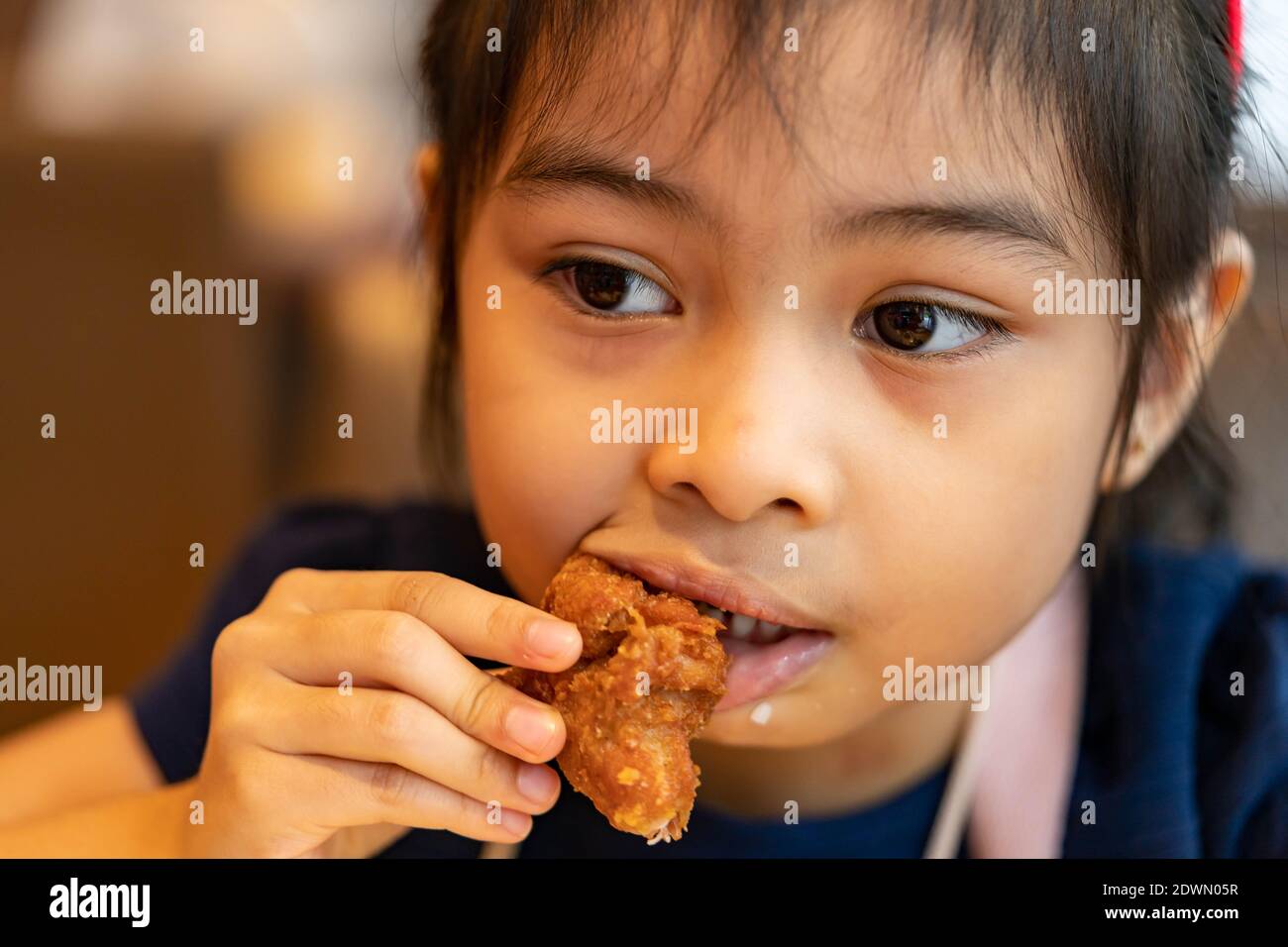Asian girl Eating Chicken. child eating a chicken nuggets Stock Photo ...