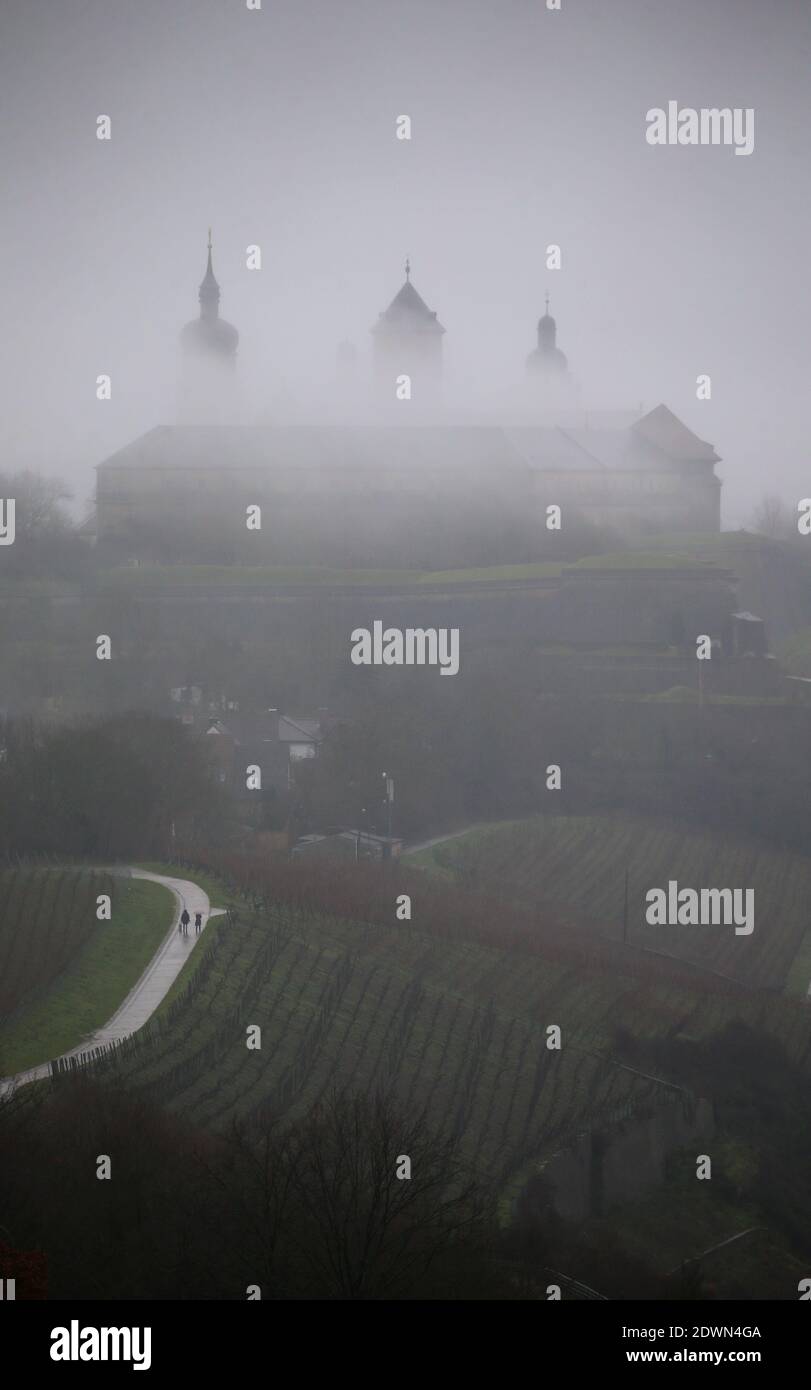 23 December 2020, Bavaria, Würzburg: Strollers walk in the fog in the ...