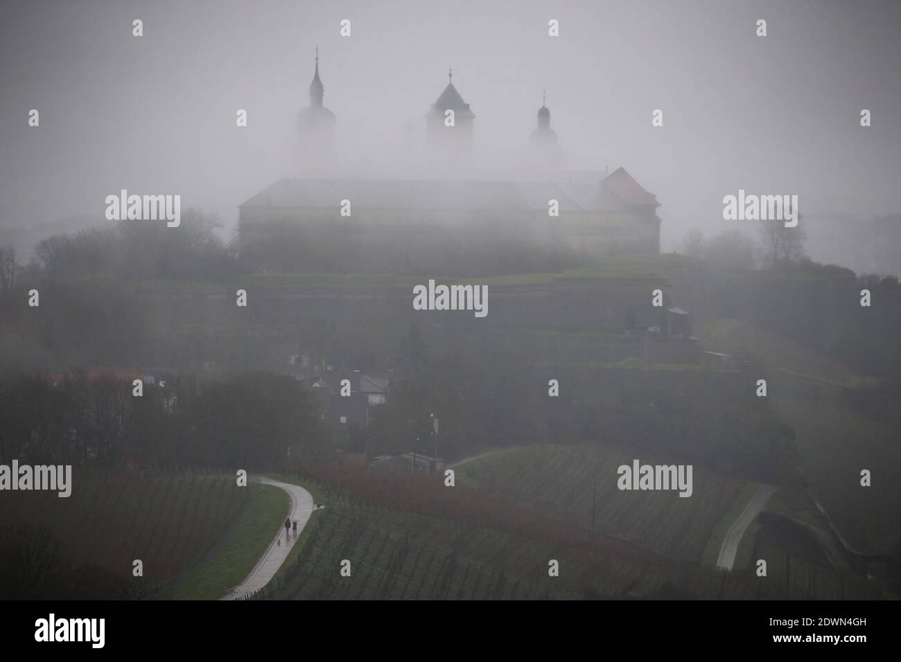 23 December 2020, Bavaria, Würzburg: Strollers walk in the fog in the ...