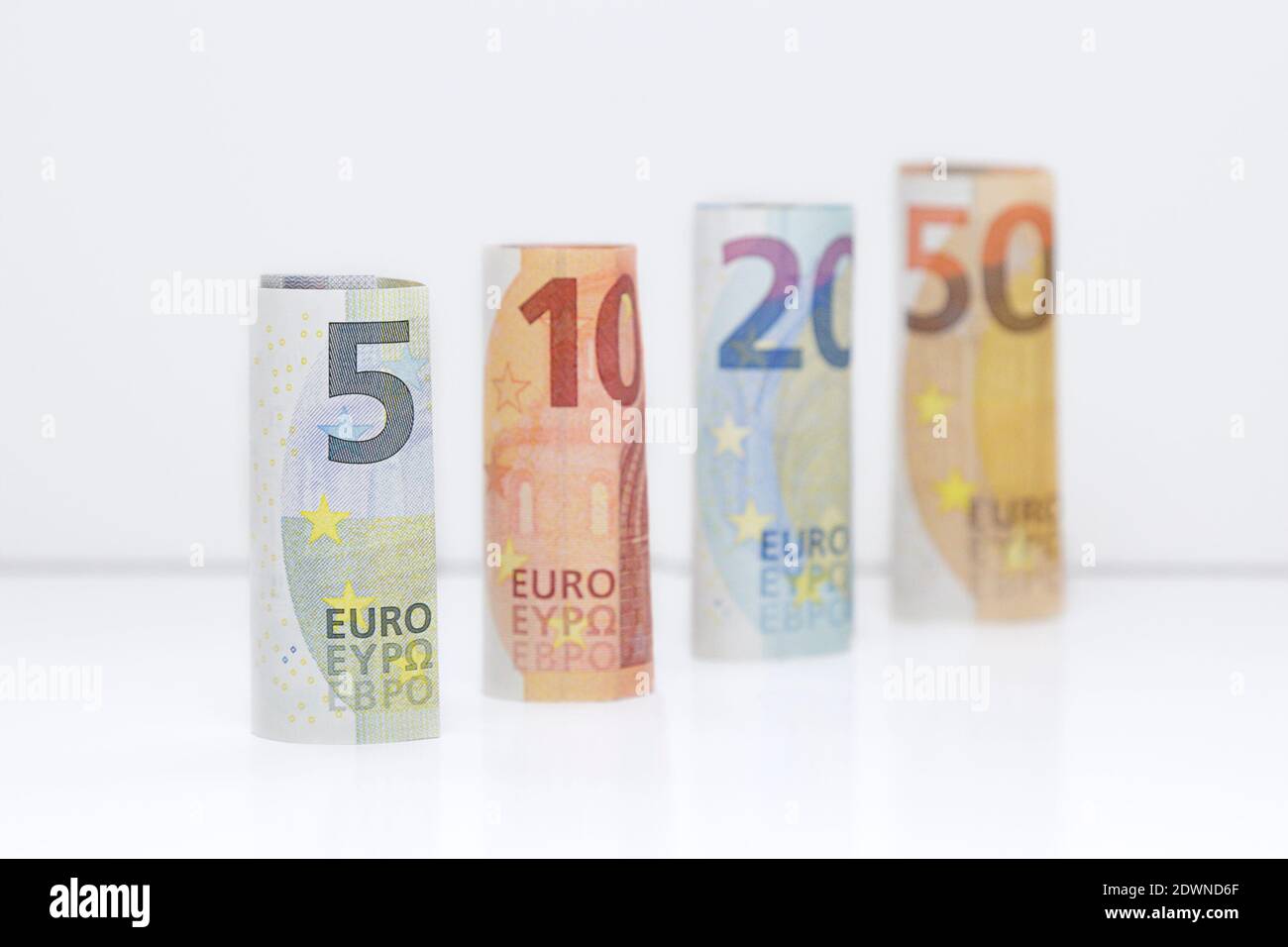 Rolled up Euro bills on white background Stock Photo - Alamy