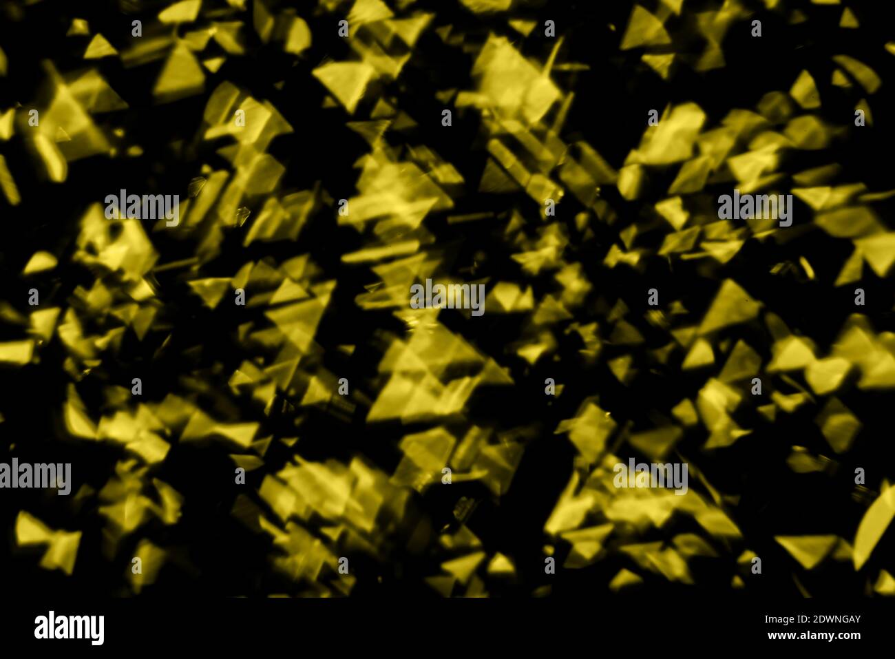 Blurred yellow sparkles on the black background. Trendy color ...