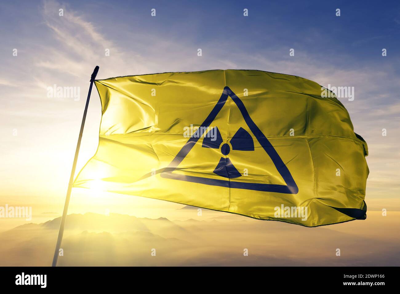 Radioactive warning label flag waving on the top sunrise mist fog Stock ...