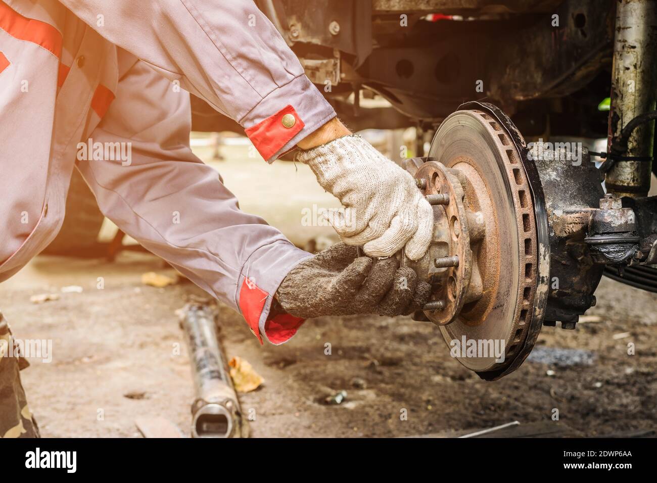 Technicians in grey uniform are repairing the brake of the car ...
