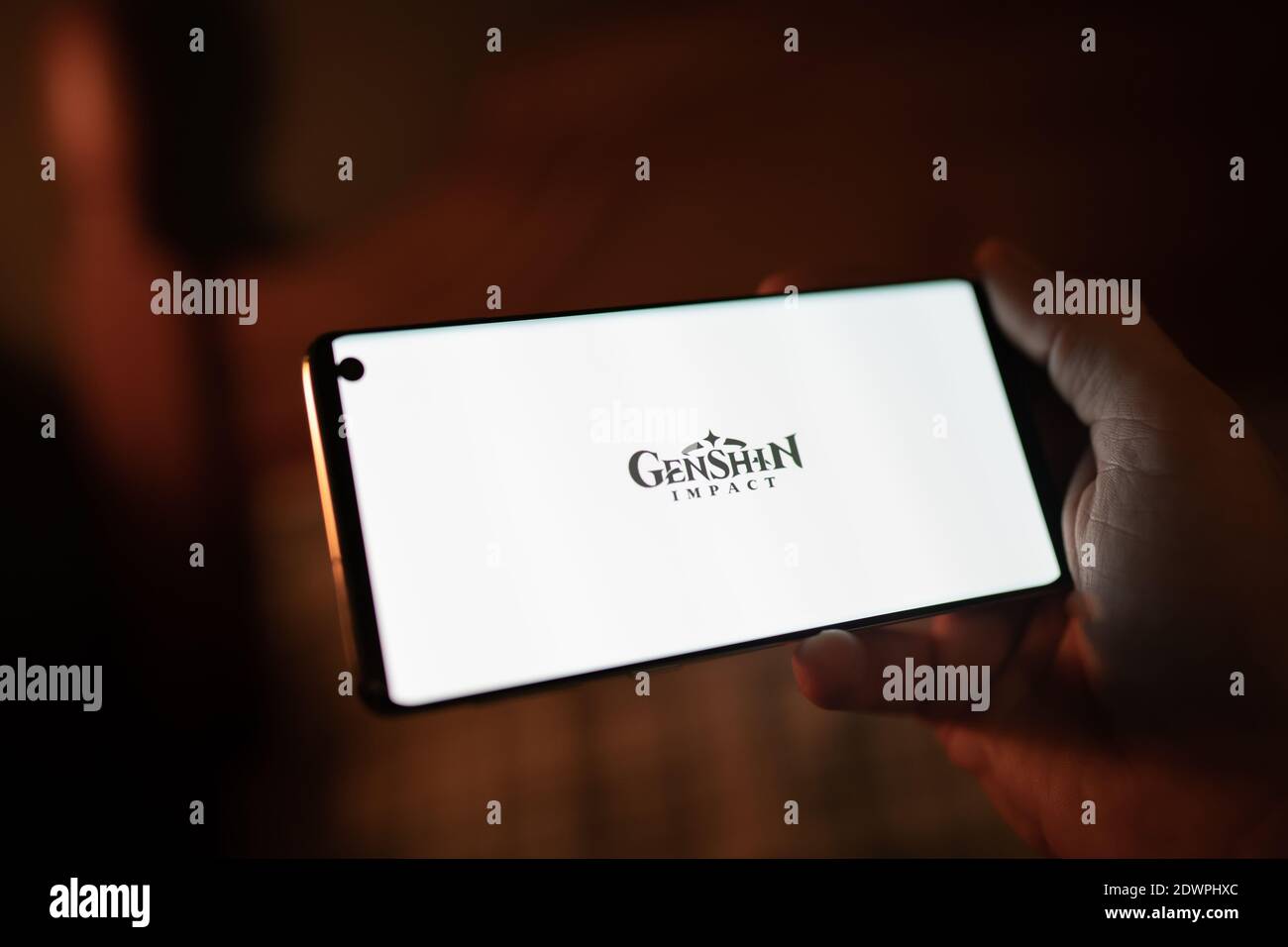 Logo of Genshin Impact game on smartphone screen. Popular worldwide ...