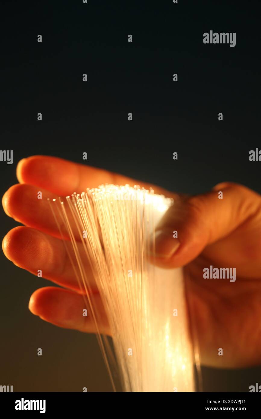 Cropped Hand Holding Illuminated Fiber Optics Against Black Background ...