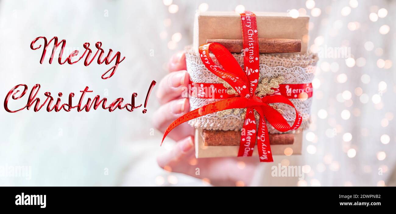 Merry Christmas text and female hands holding a Christmas gift isolated ...