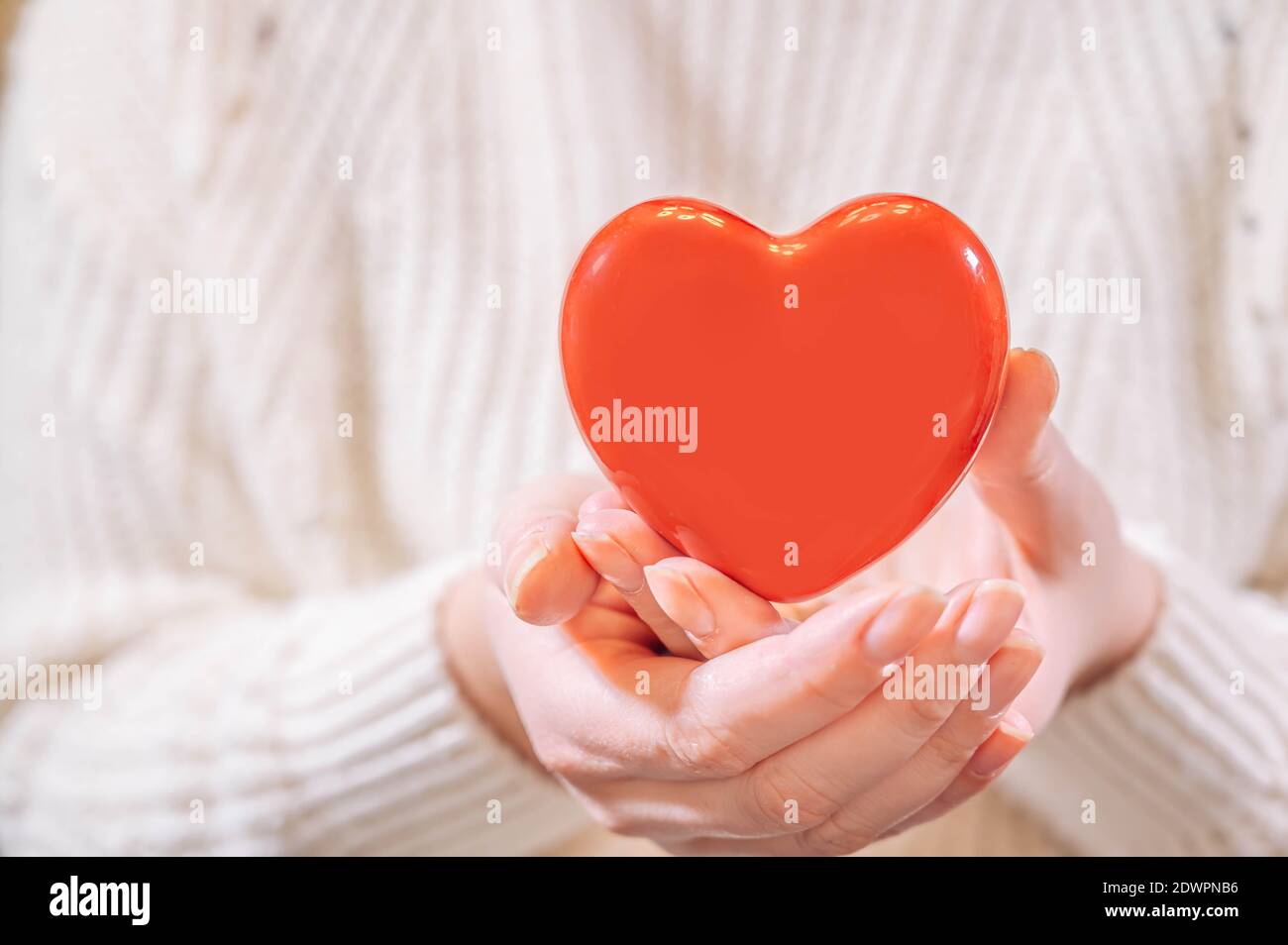 Giving love concept with hands holding a red heart. Philanthropy ...