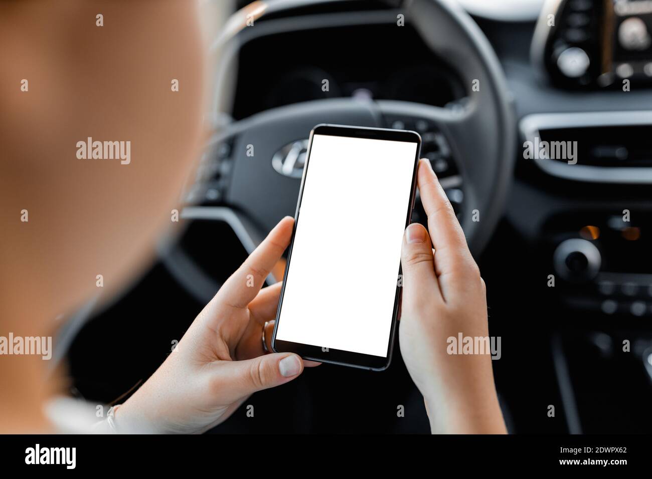 Young driver using smartphon in the car while driving or parking ...