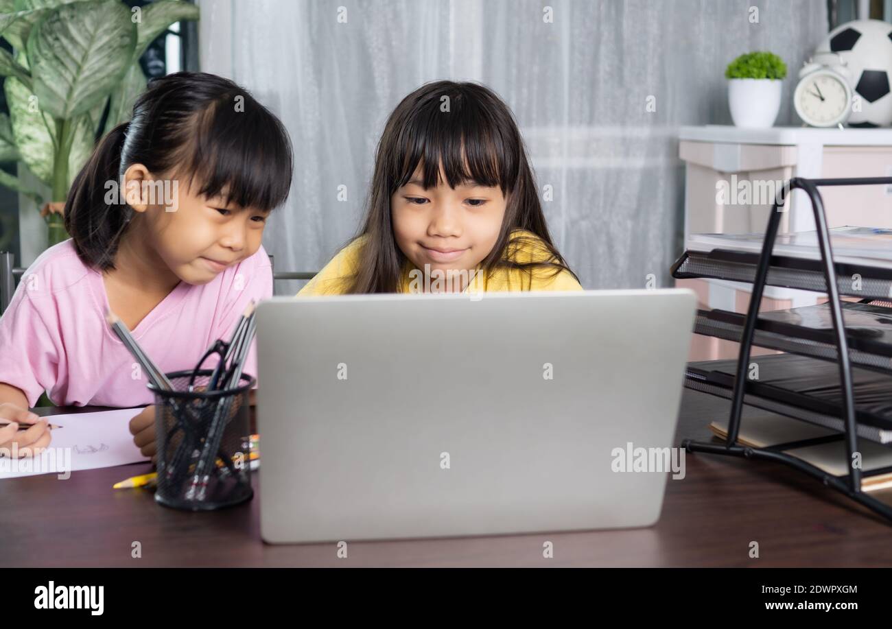 Younger and older sister study and learning online at home, education ...
