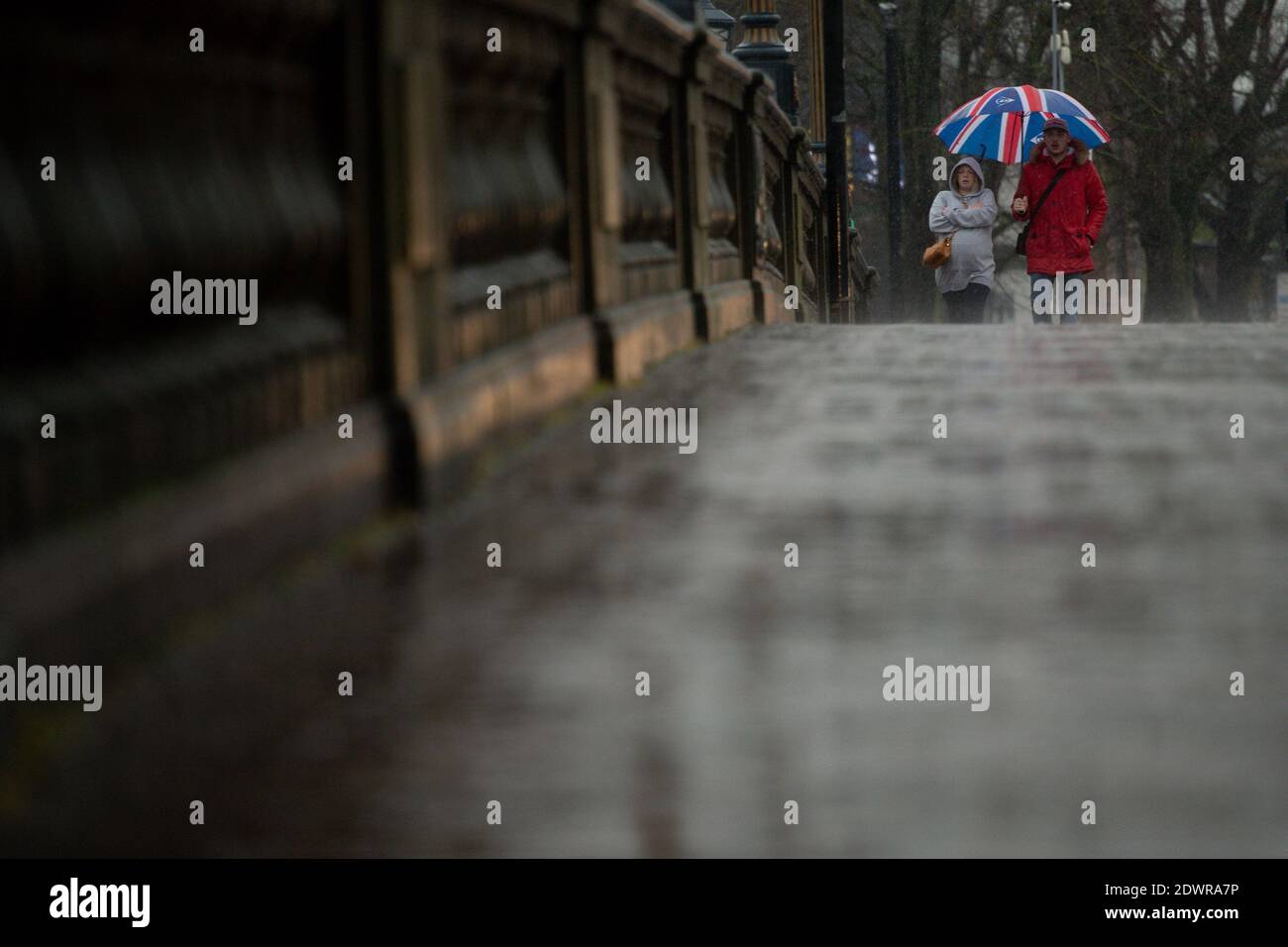 People shield themselves from heavy rain as they walk in Worcester ...