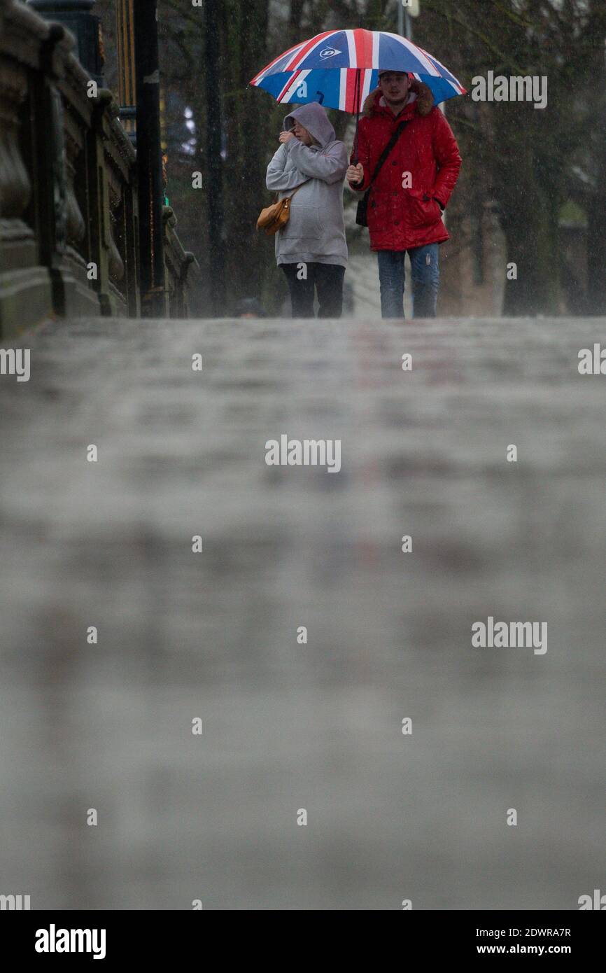 People shield themselves from heavy rain as they walk in Worcester ...
