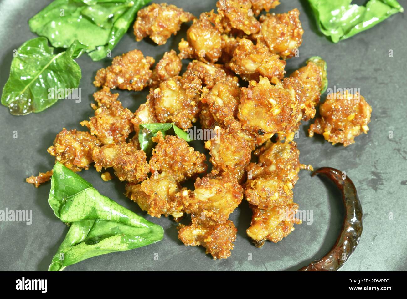 spicy fried chicken tendon with chili and lemon leaf on dish Stock ...