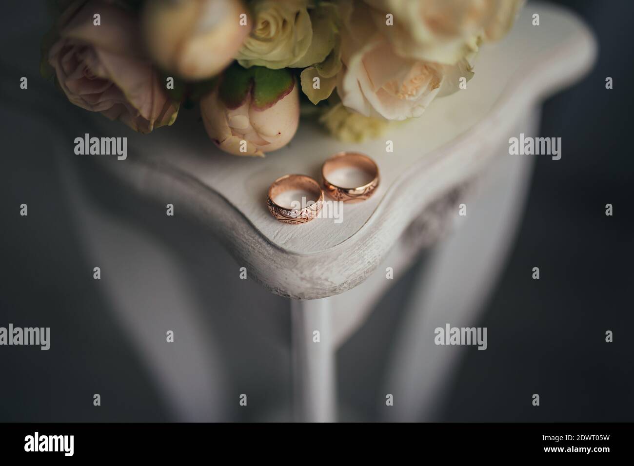 Wedding rings with flowers on the table Stock Photo - Alamy