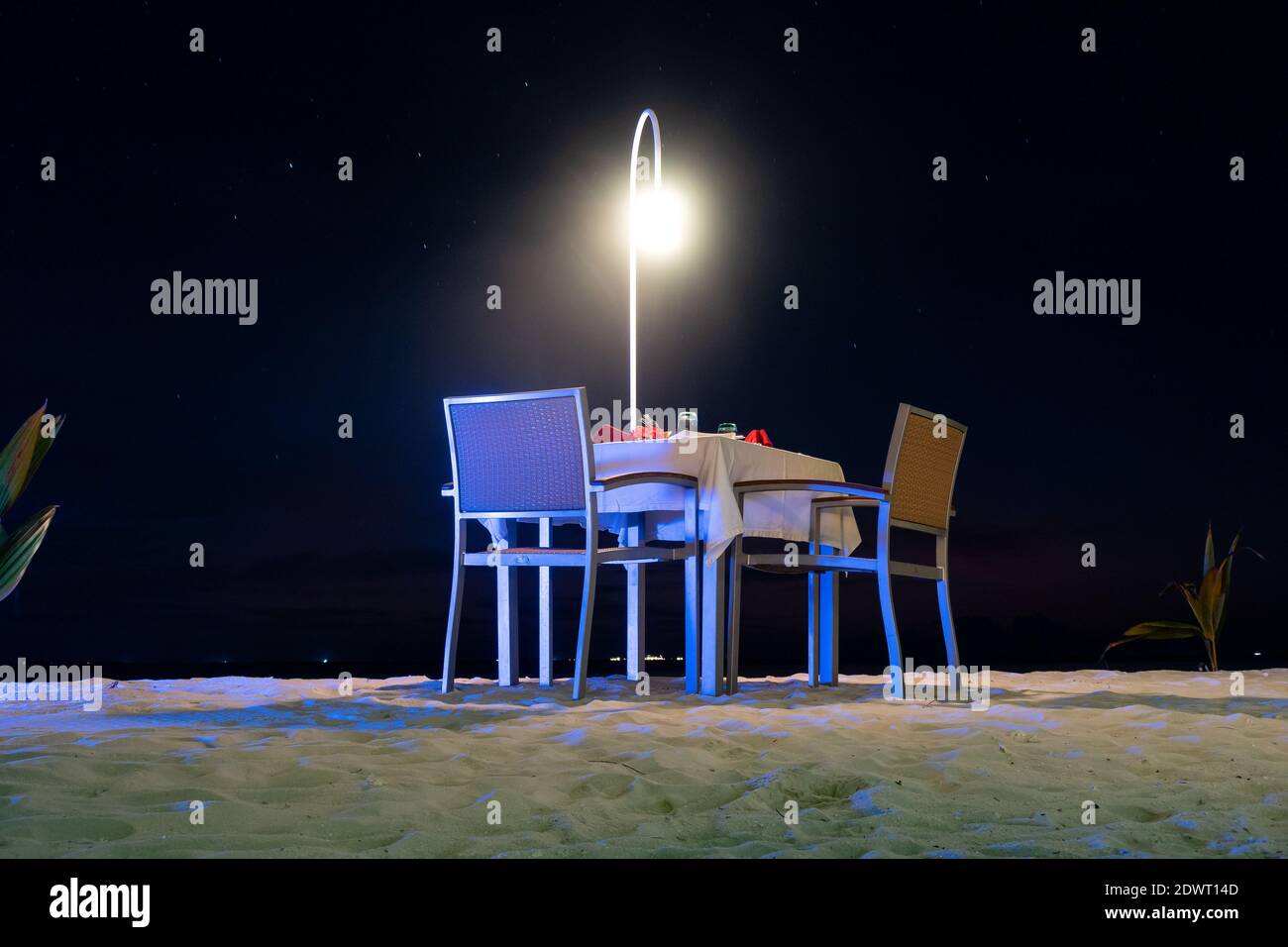Dining table on the sandy beach at night, romantic dining in luxury ...