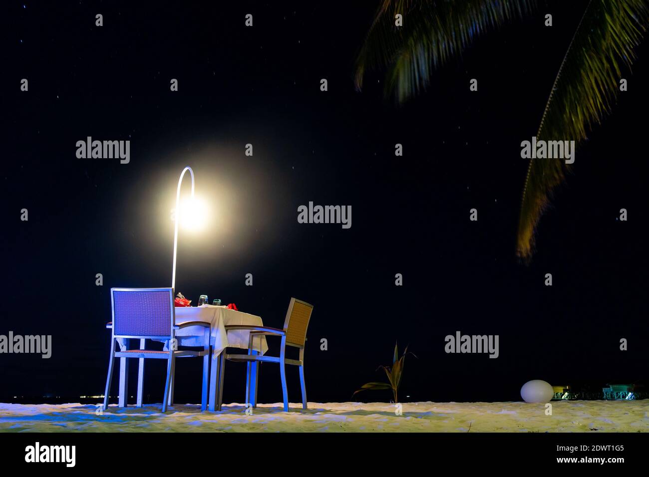 Dining table on the sandy beach at night, romantic dining in luxury ...