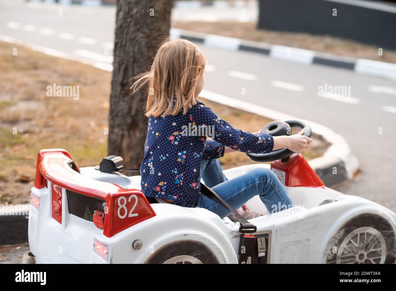 Little girl driving car on kids road in adventure park Stock Photo - Alamy
