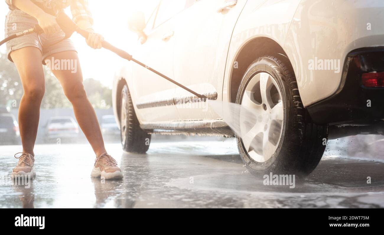 Girl using pressure water on self service car wash Stock Photo - Alamy
