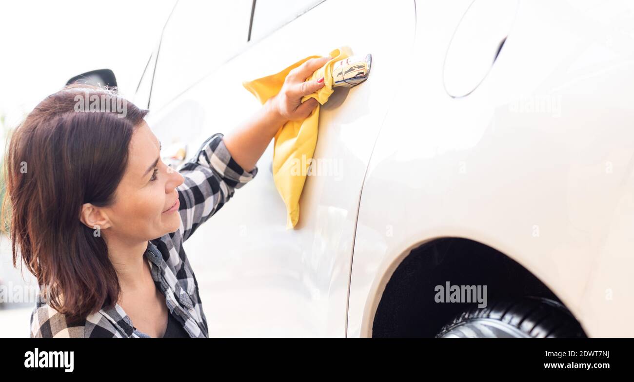 Woman polishing car door handle with microfiber rag Stock Photo - Alamy