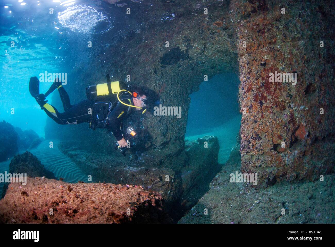 Scuba diver swimming through submerged ancient Roman building ruines ...