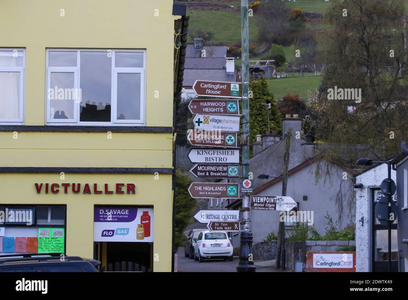 Lamp post with tourist information and direction signs in Carlingford ...