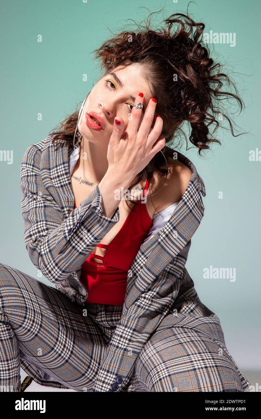 White european girl model in suit sitting isolated on green Stock Photo ...