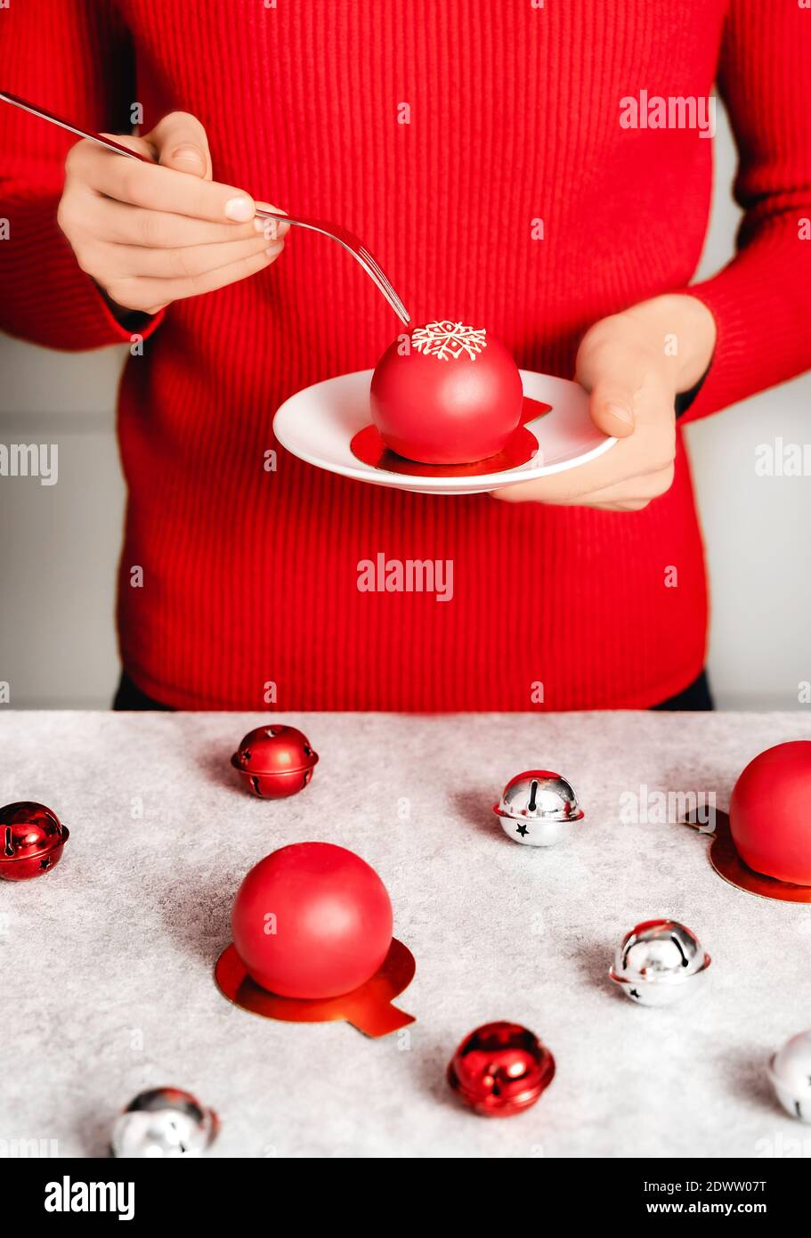 Beautiful young female hands holding red ball mousse dessert decorated ...