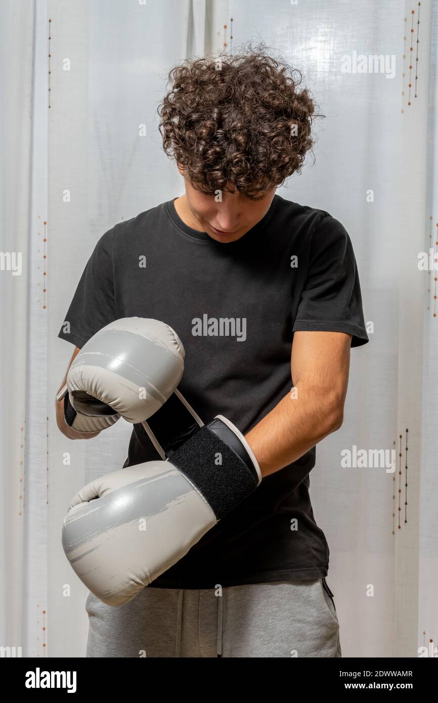 Attractive young man with curly hair wearing black t-shirt posing with ...