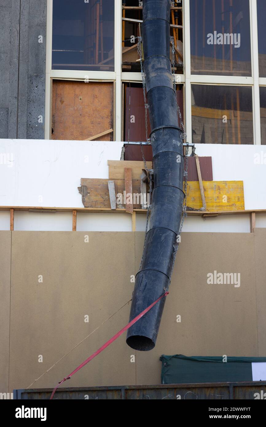 Vertical black debris chute on building construction site Stock Photo ...