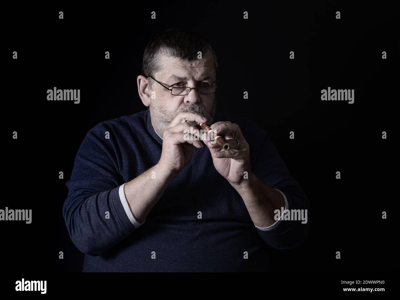 Low key portrait of old bearded Caucasian musician wearing glasses and ...