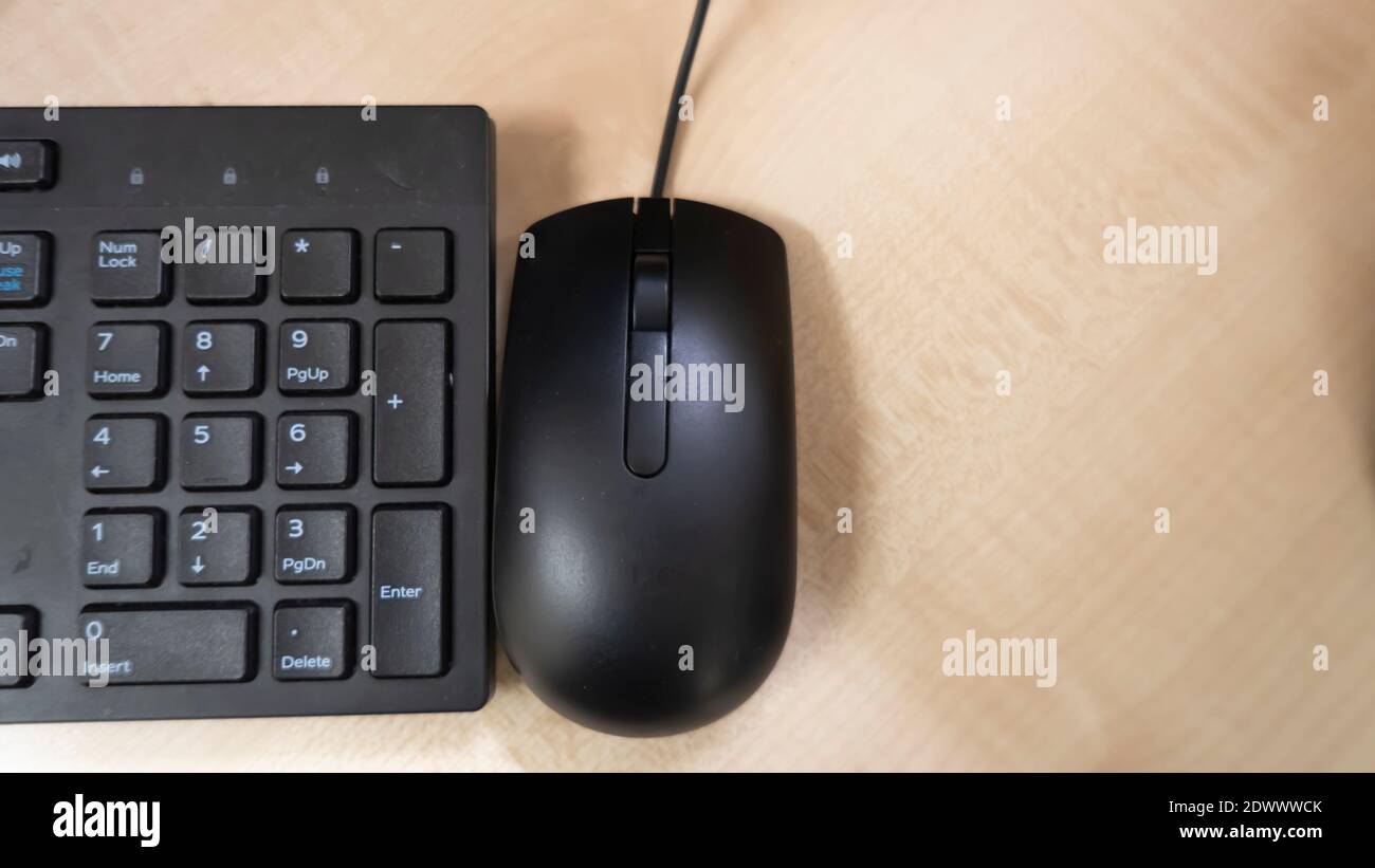 A workspace of an office which include mouse keyboard and wooden table ...