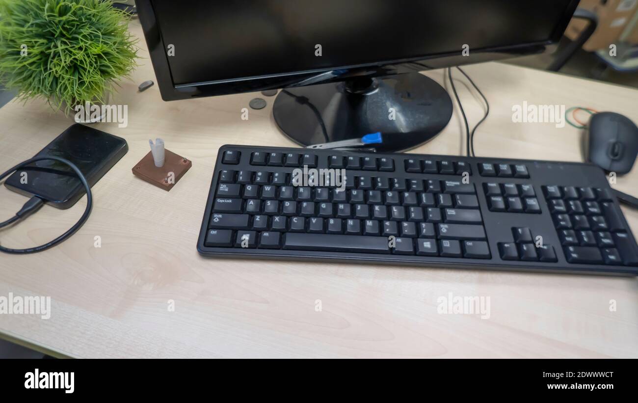 A workspace of an office which include mouse keyboard and wooden table ...
