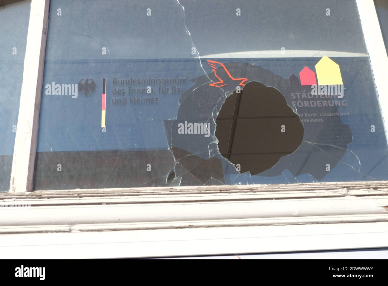 Broken window at offices with government and regional government logos ...