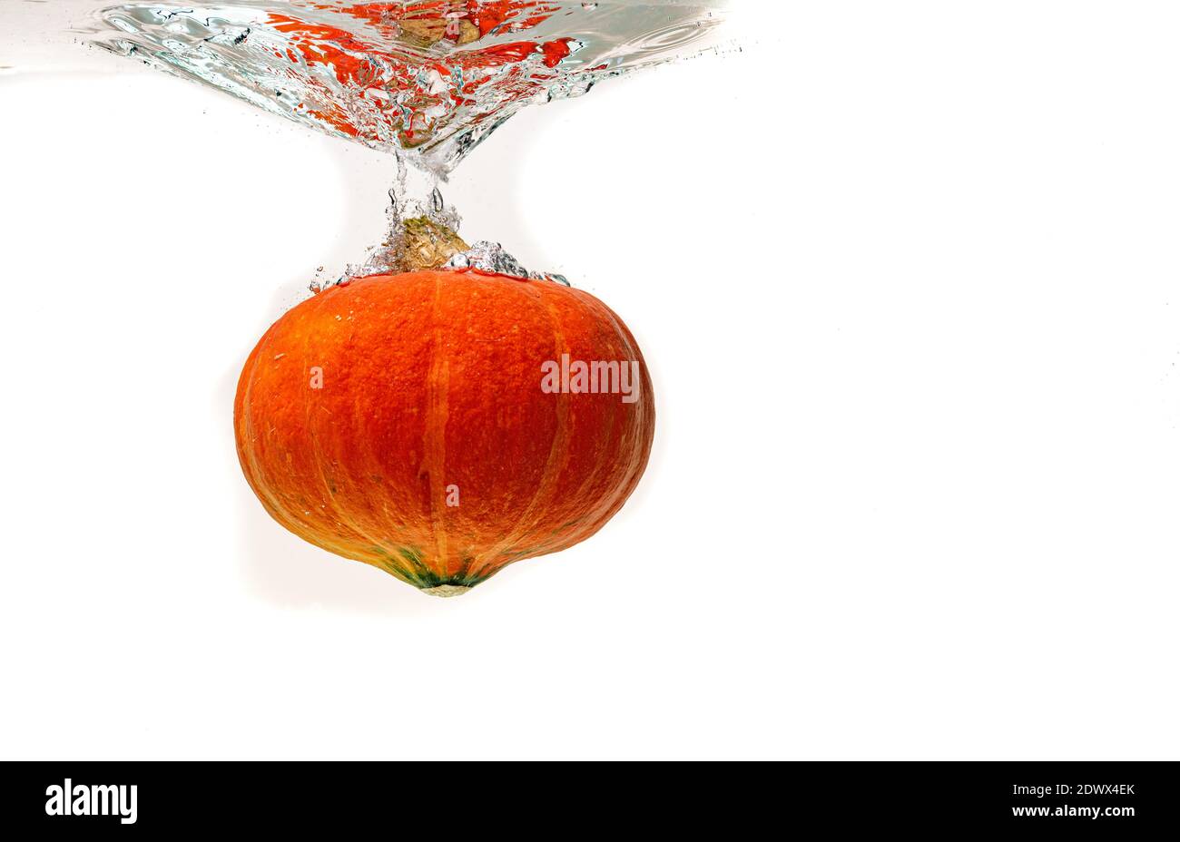 Orange pumpkin splashing into water isolated against white background ...