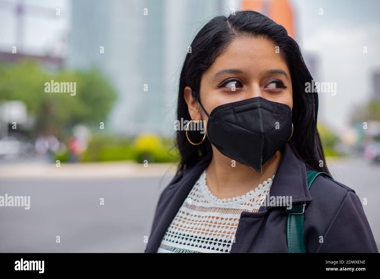 Latin businesswoman wearing a face mask for protective reasons during ...