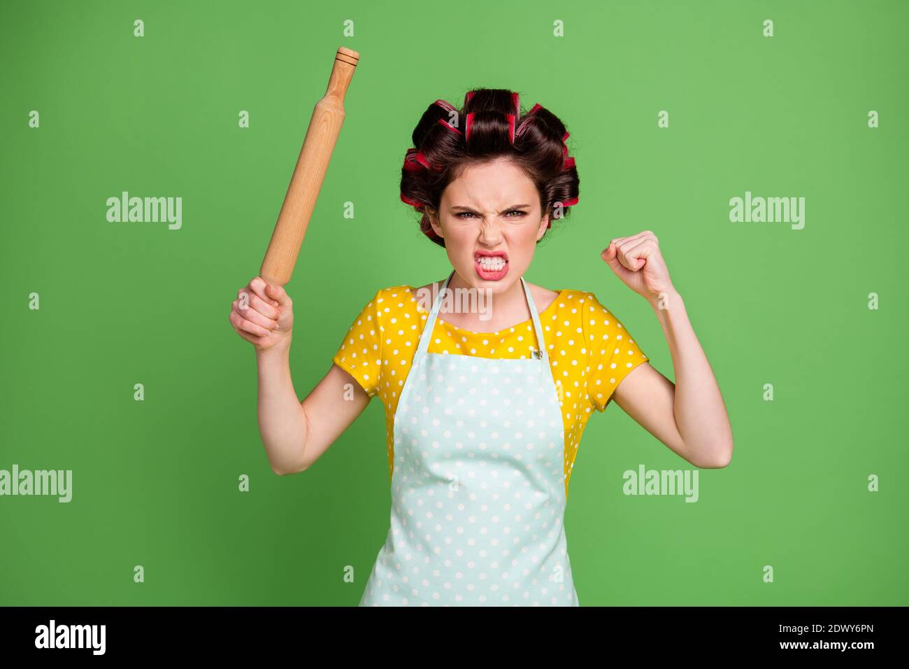 Photo of crazy evil furious lady curlers hairdo housewife hold rolling ...